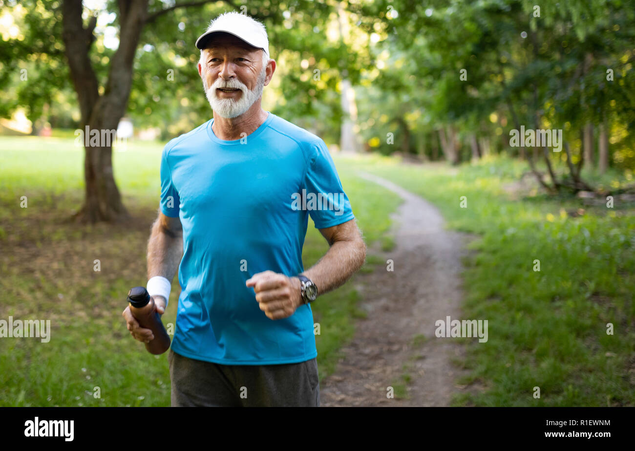 Attractive retired man with a nice smile jogging in park Stock Photo ...