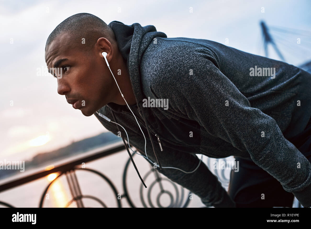 Tired because of running. Young jogger is stopped to catch his breath ...