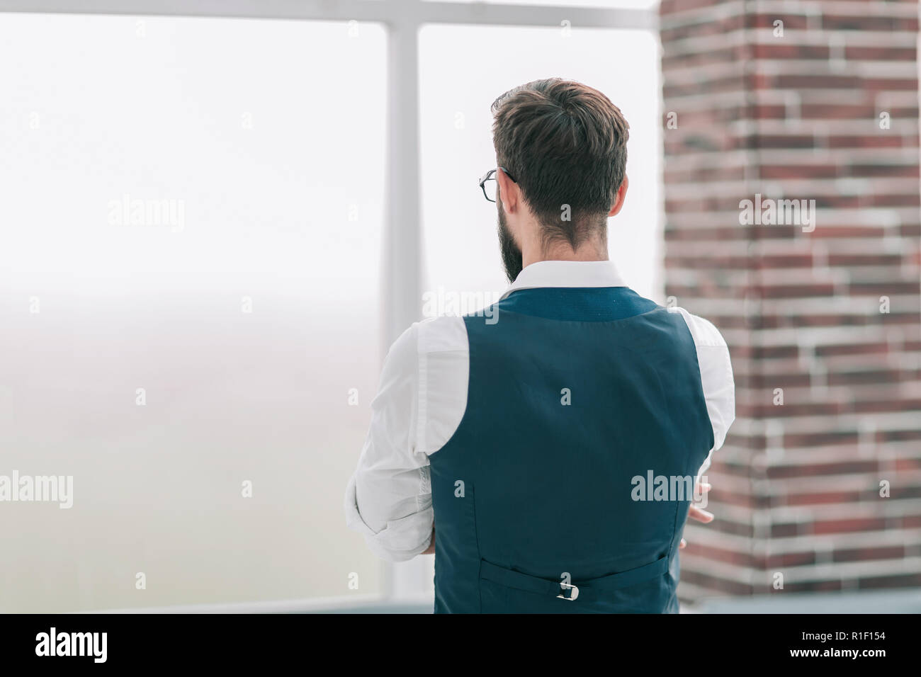 rear view. businessman looking through office window Stock Photo - Alamy