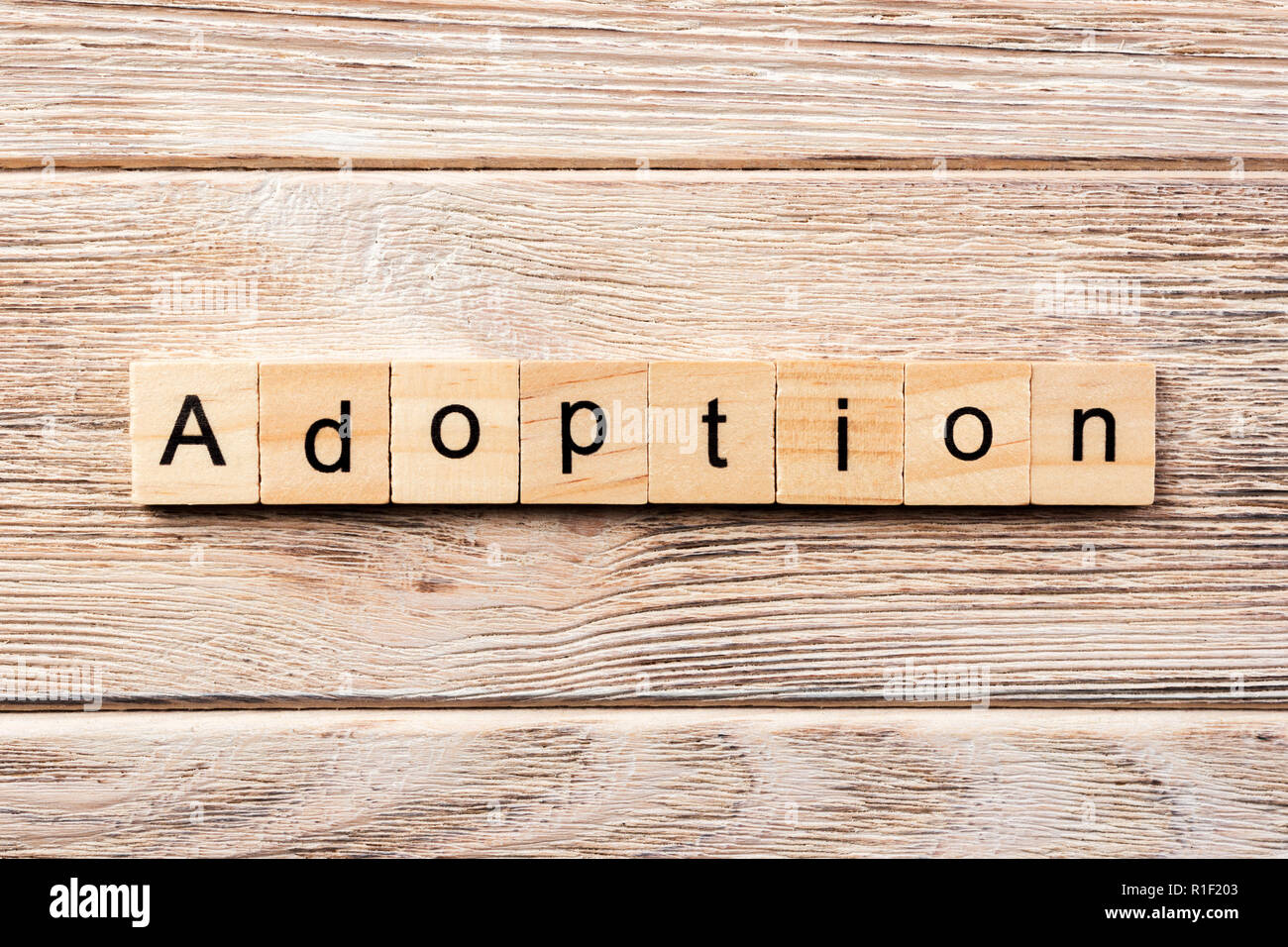 adoption word written on wood block. adoption text on table, concept ...