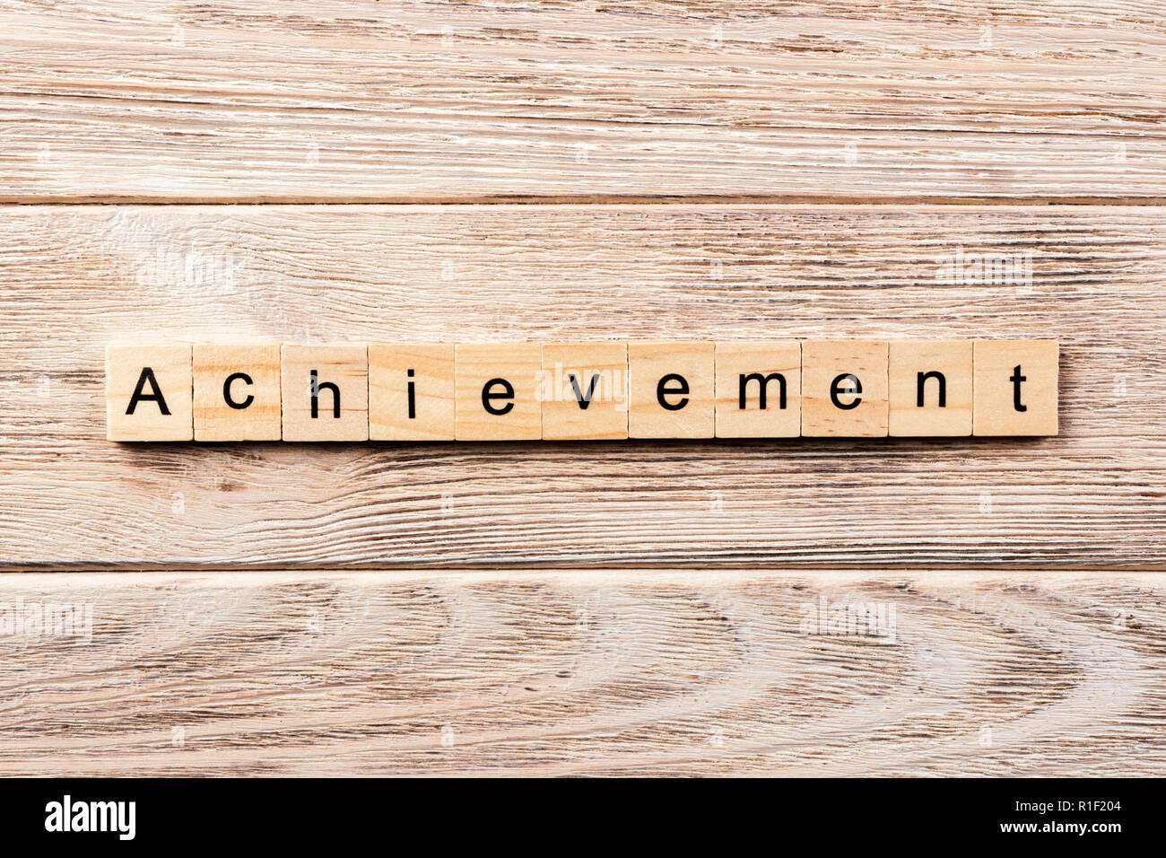 achievement word written on wood block. achievement text on table ...
