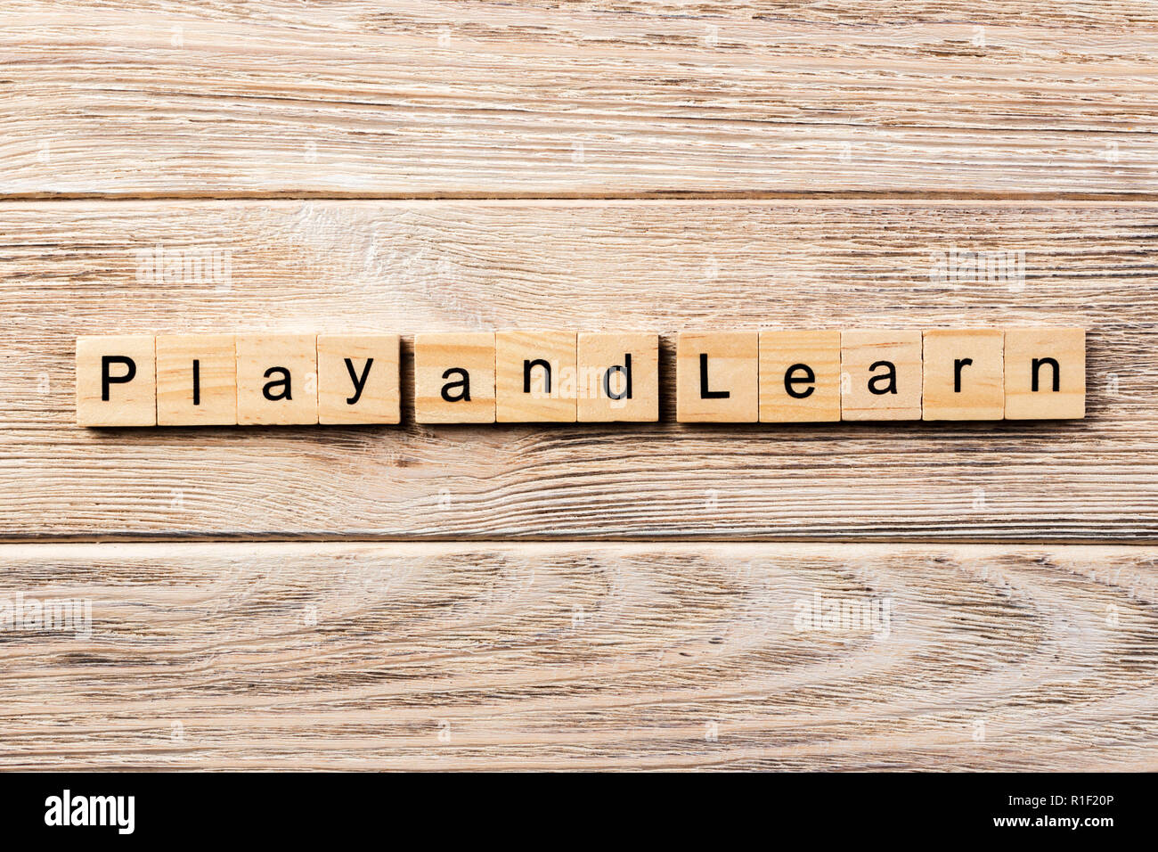 play and learn word written on wood block. play and learn text on table ...