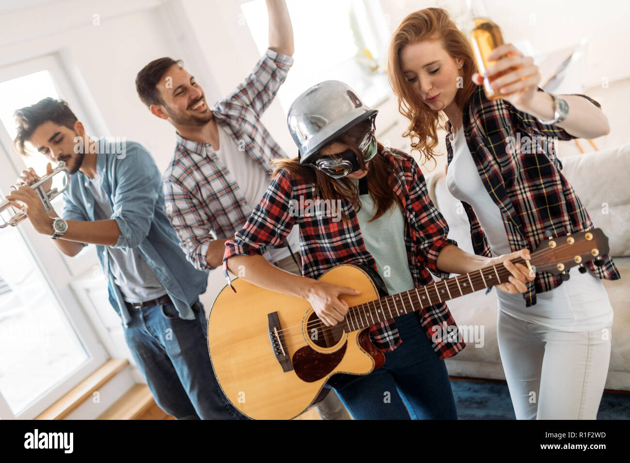 Cheerful friends having party together and playing instruments Stock ...