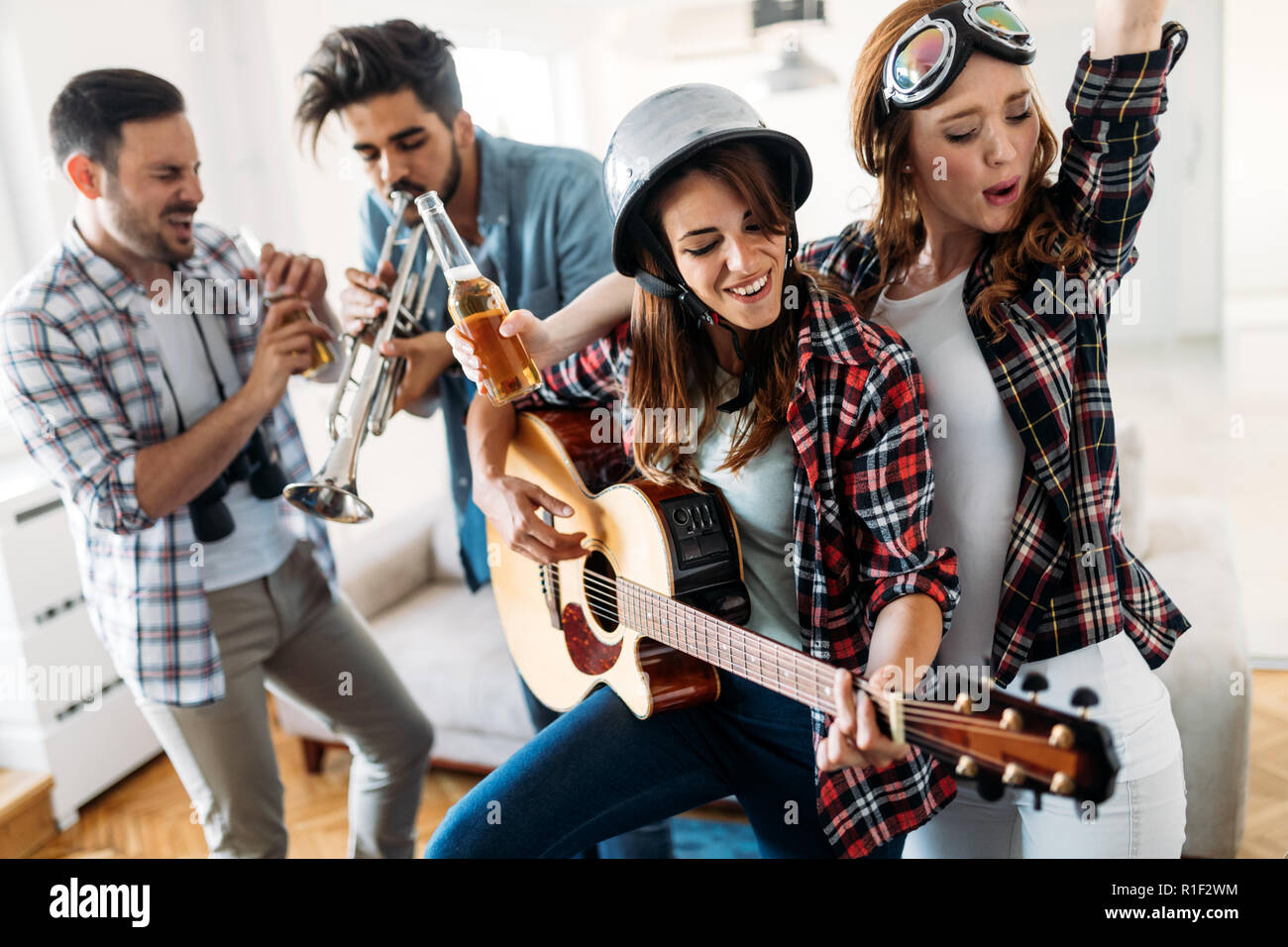 Cheerful friends having party together and playing instruments Stock ...