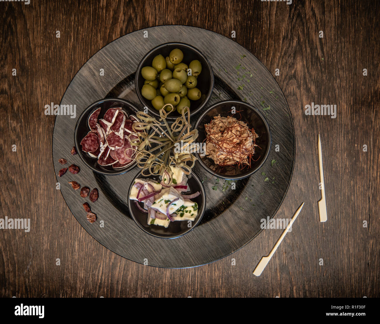 tapas food served in bowls on big brown plate on wooden table with ...