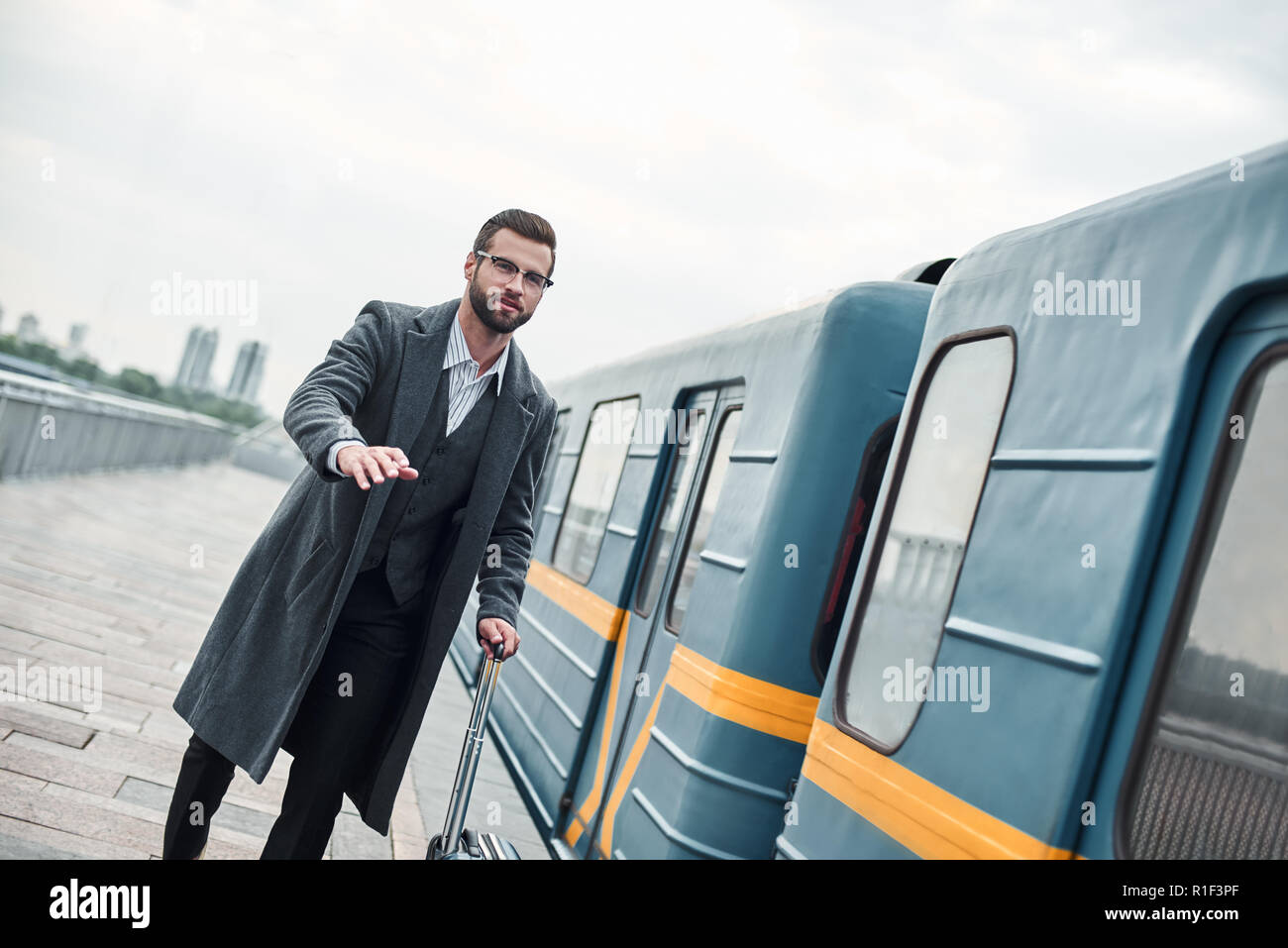 Late for train. Young businessman running near railway with luggage ...