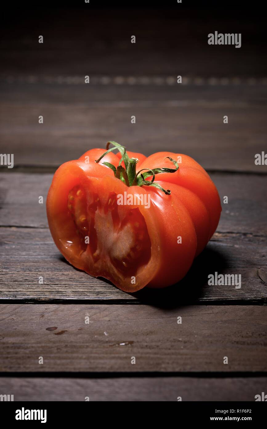 Tomato on a wood table Stock Photo - Alamy