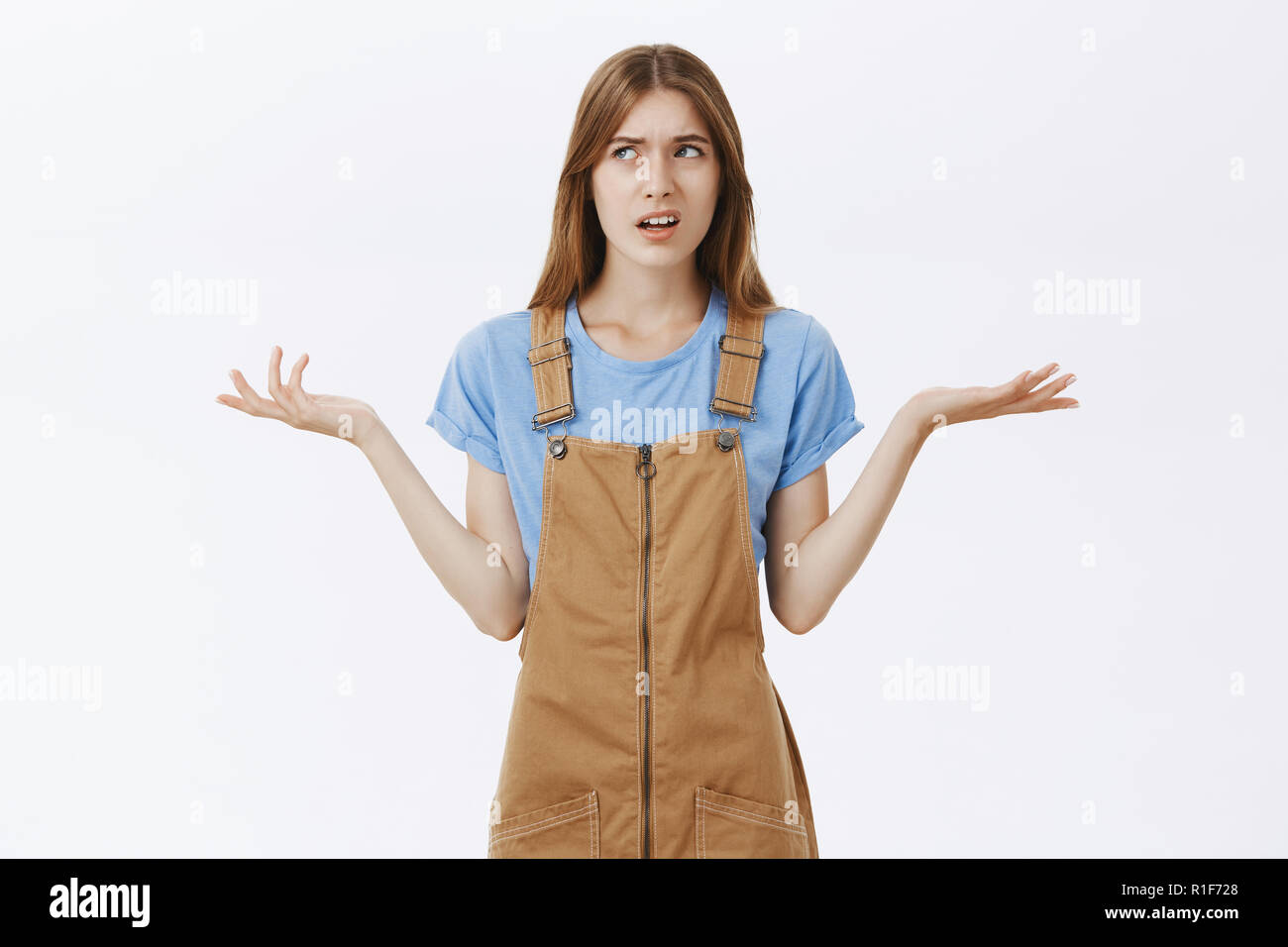 Studio shot of displeased bothered and questioned daughter in brown ...