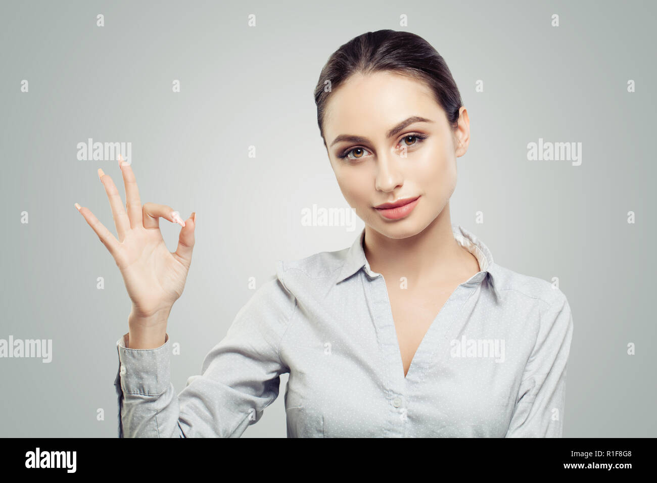 Portrait of beautiful young woman showing okay sign gesture. Face ...