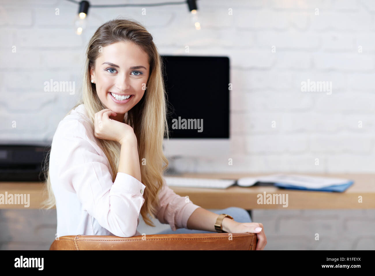 Portrait of beautiful millennial woman working in modern home office ...