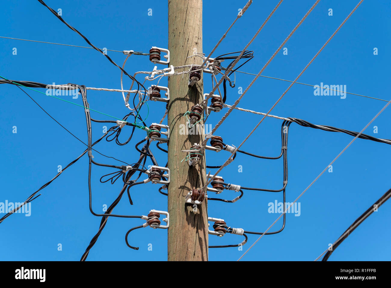 Electric cables tangle on old wood post Stock Photo - Alamy