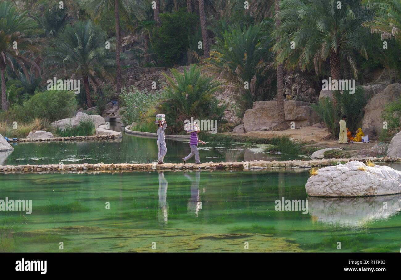 Wadi Bani Khalid, Oman. 25th Nov, 2012. Two men carry beverage cartons ...