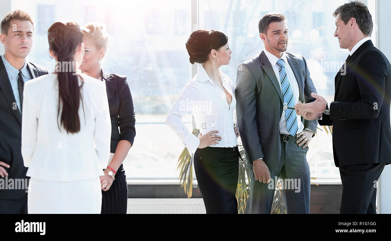 group of business people talking,standing in the lobby of the office ...