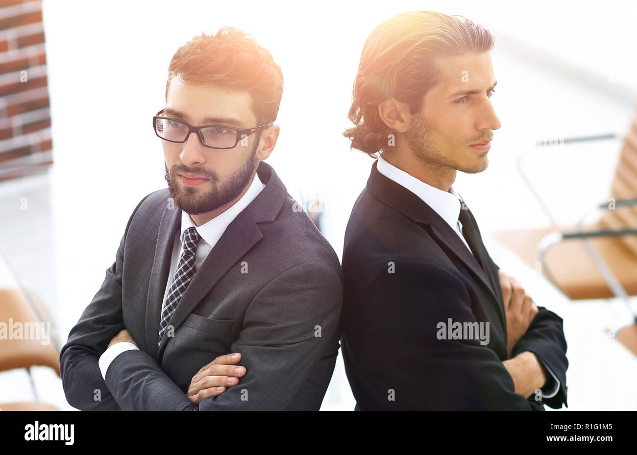 Two men standing back to back and support each other Stock Photo - Alamy