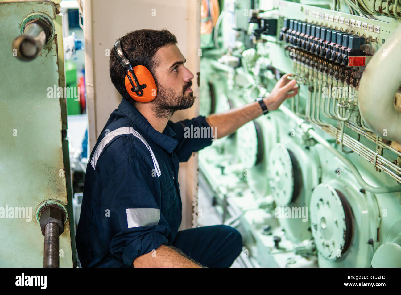 Marine engineer officer working in engine room Stock Photo - Alamy