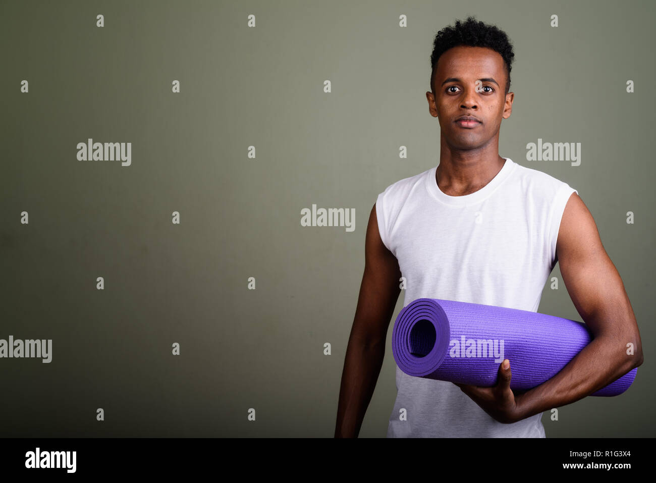 Young handsome African man ready for gym against colored backgro Stock ...