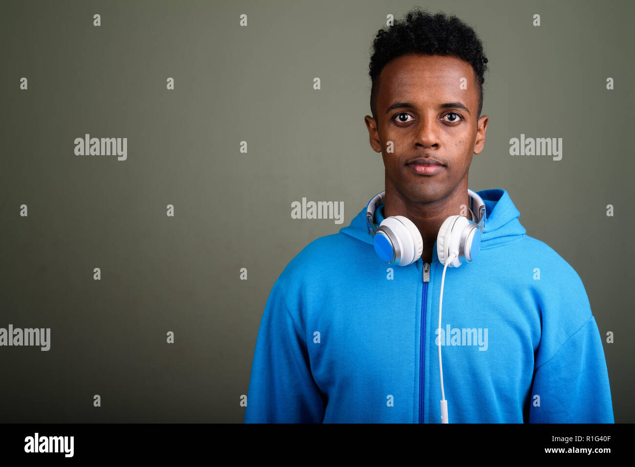 Young handsome African man wearing headphones against colored ba Stock ...