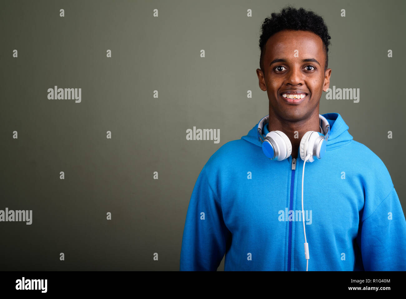 Young handsome African man wearing headphones against colored ba Stock ...