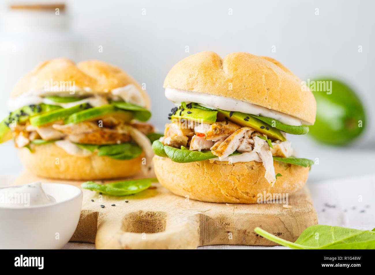 Grilled chicken and avocado burger on wooden board. Healthy food ...
