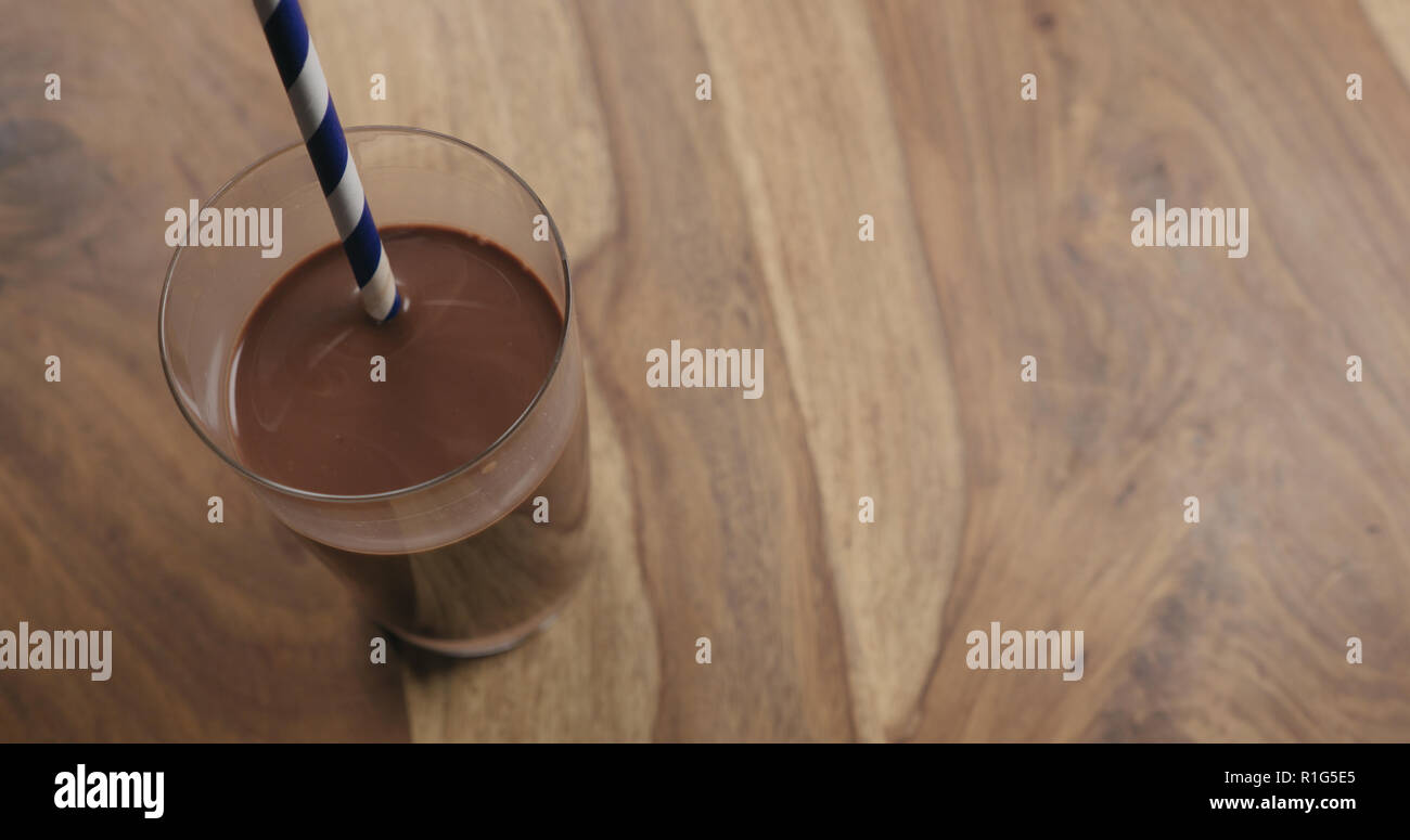 Cocoa with blue striped paper straw on wood background with copy space ...