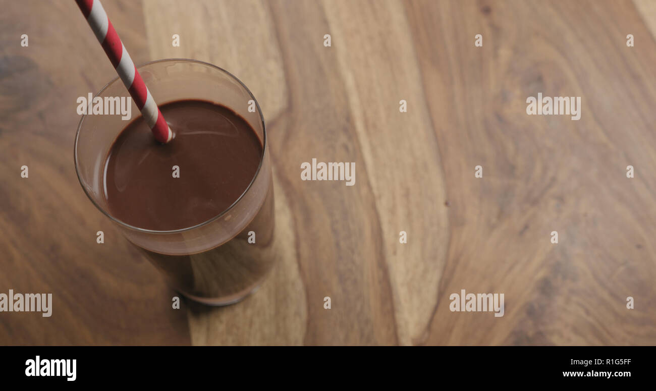 Cocoa with red striped paper straw on wood background with copy space ...