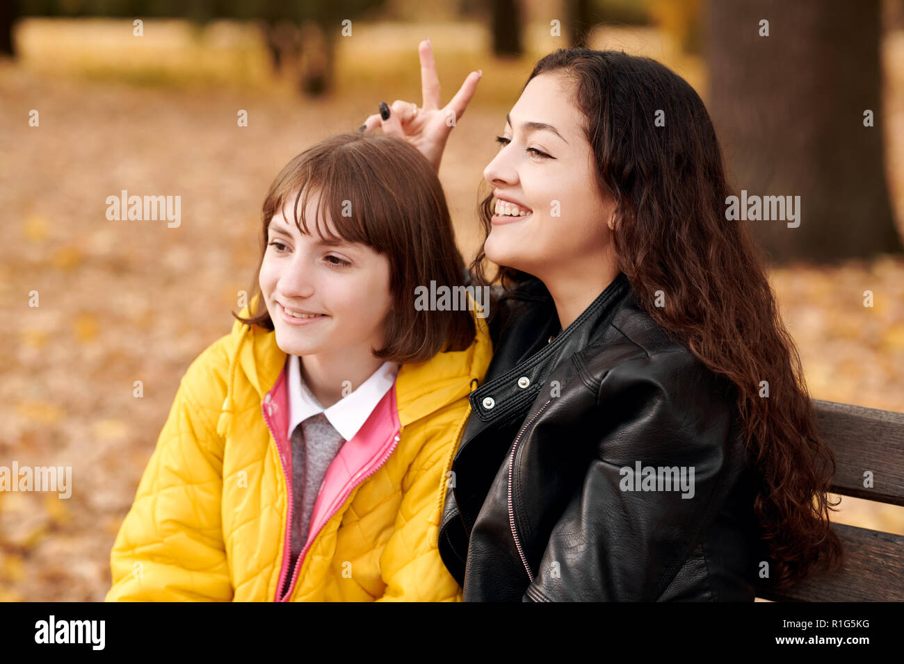 Two girls sister posing in city park hi-res stock photography and ...