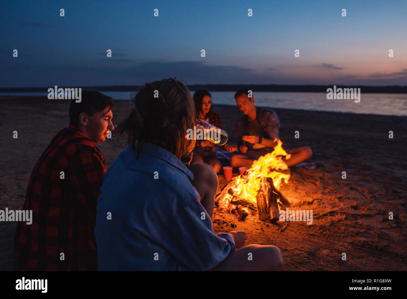 young friends have picnic with bonfire on the beach Stock Photo - Alamy