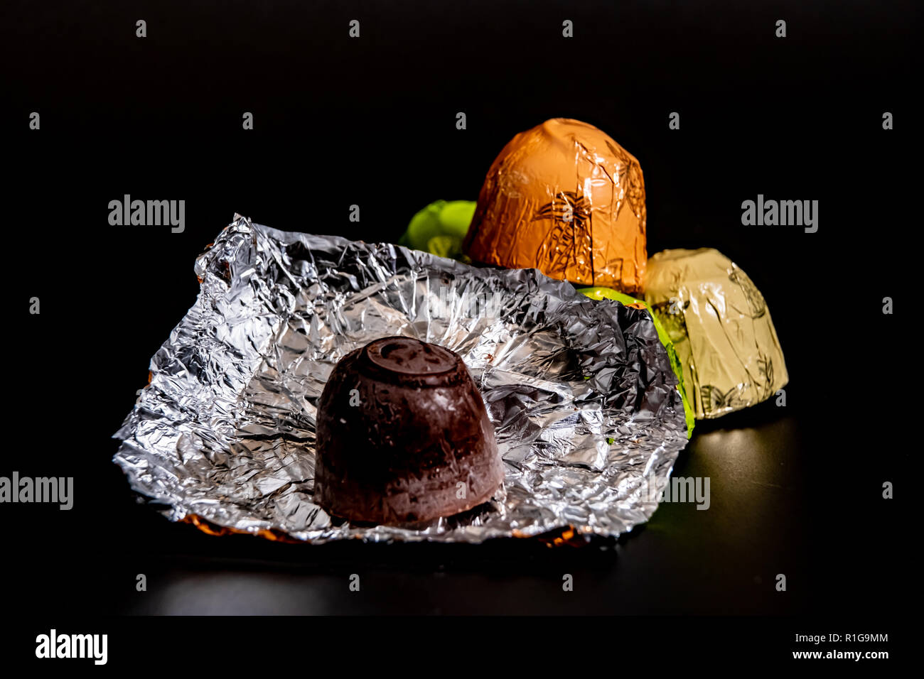 Chocolates in foil wrapper on black background 2018 Stock Photo - Alamy