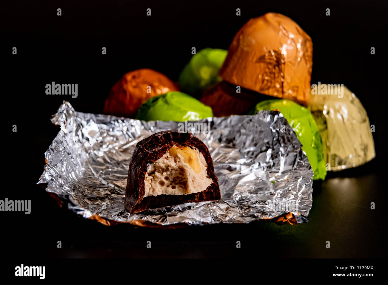 Chocolates in foil wrapper on black background 2018 Stock Photo - Alamy
