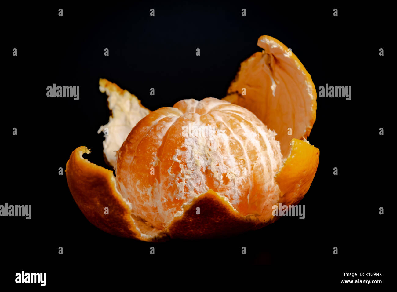Half peeled mandarin on a black background close-up 2018 Stock Photo ...