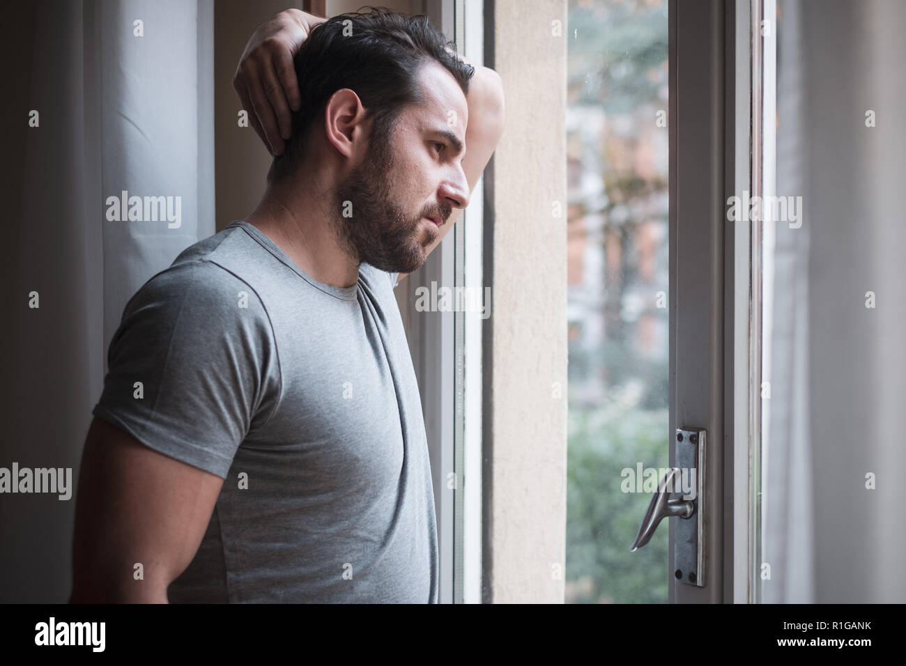 Man depressed home window hi-res stock photography and images - Alamy