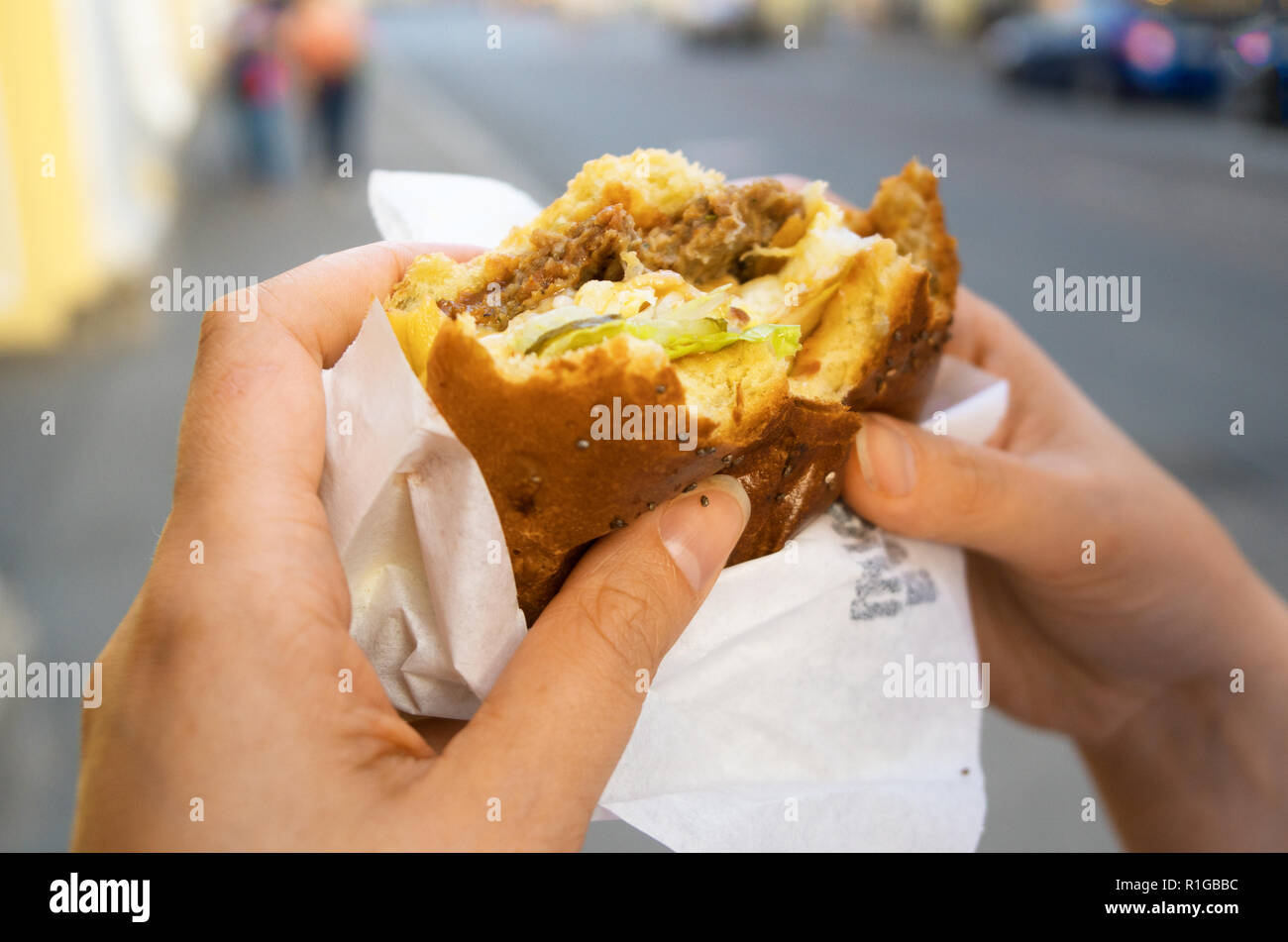 Woman eating hamburger on street hi-res stock photography and images ...