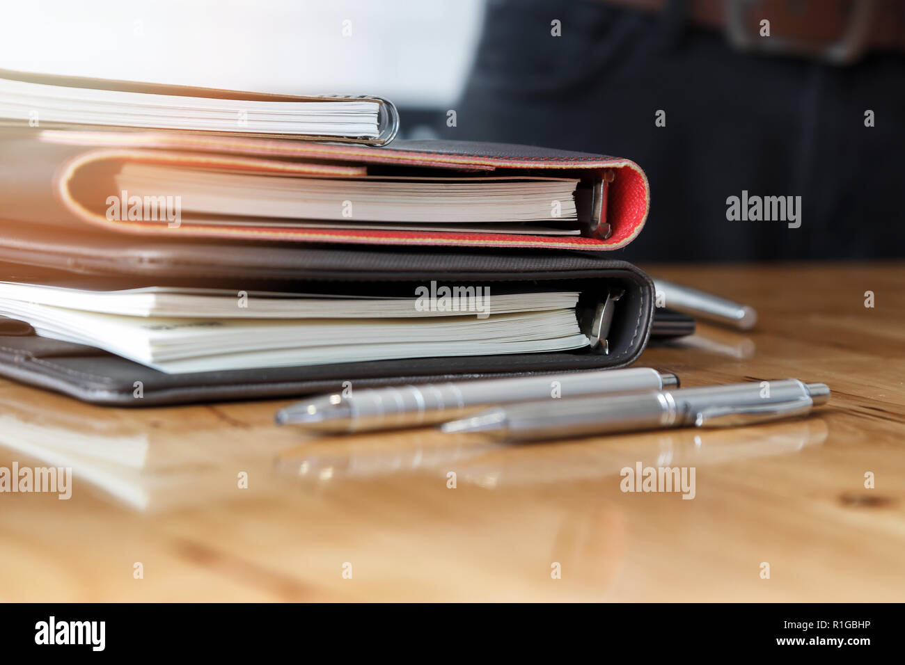 Stack of notebooks and pens on office desk Stock Photo - Alamy