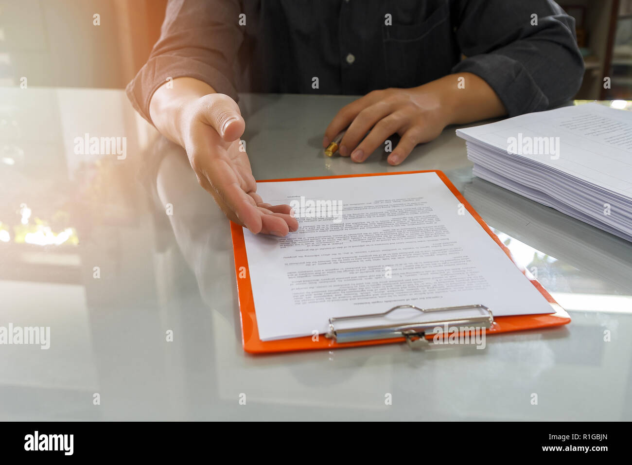 Businessman offering contract paper to his business partner for sign ...