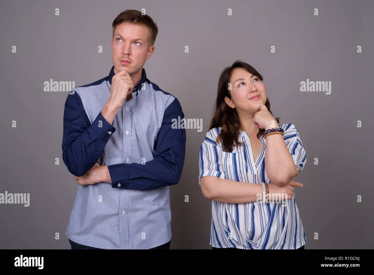 Portrait of multi ethnic diverse couple thinking Stock Photo - Alamy