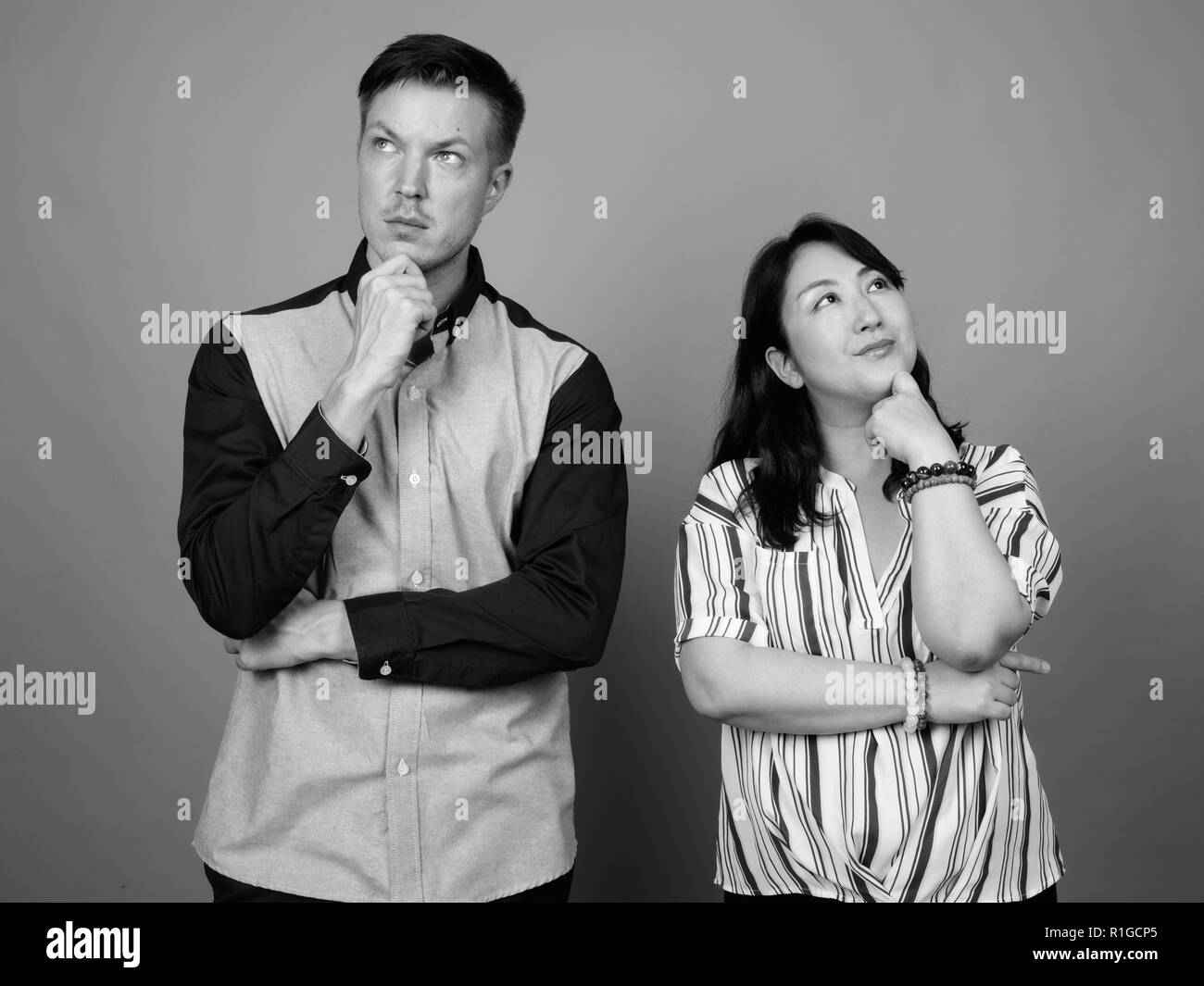 Portrait of multi ethnic diverse couple thinking Stock Photo - Alamy