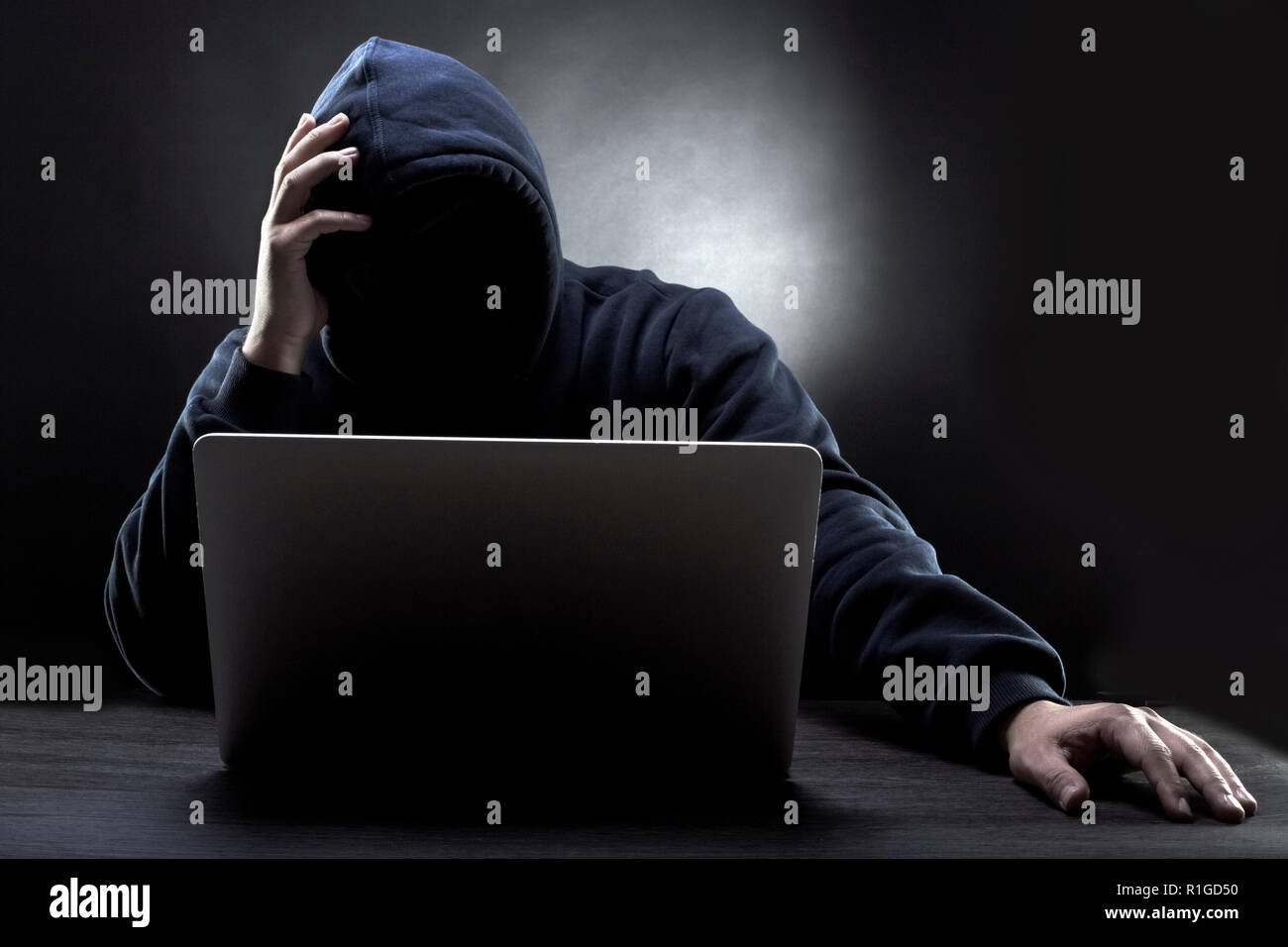 tired hacker without face in a hood on a dark background Stock Photo ...