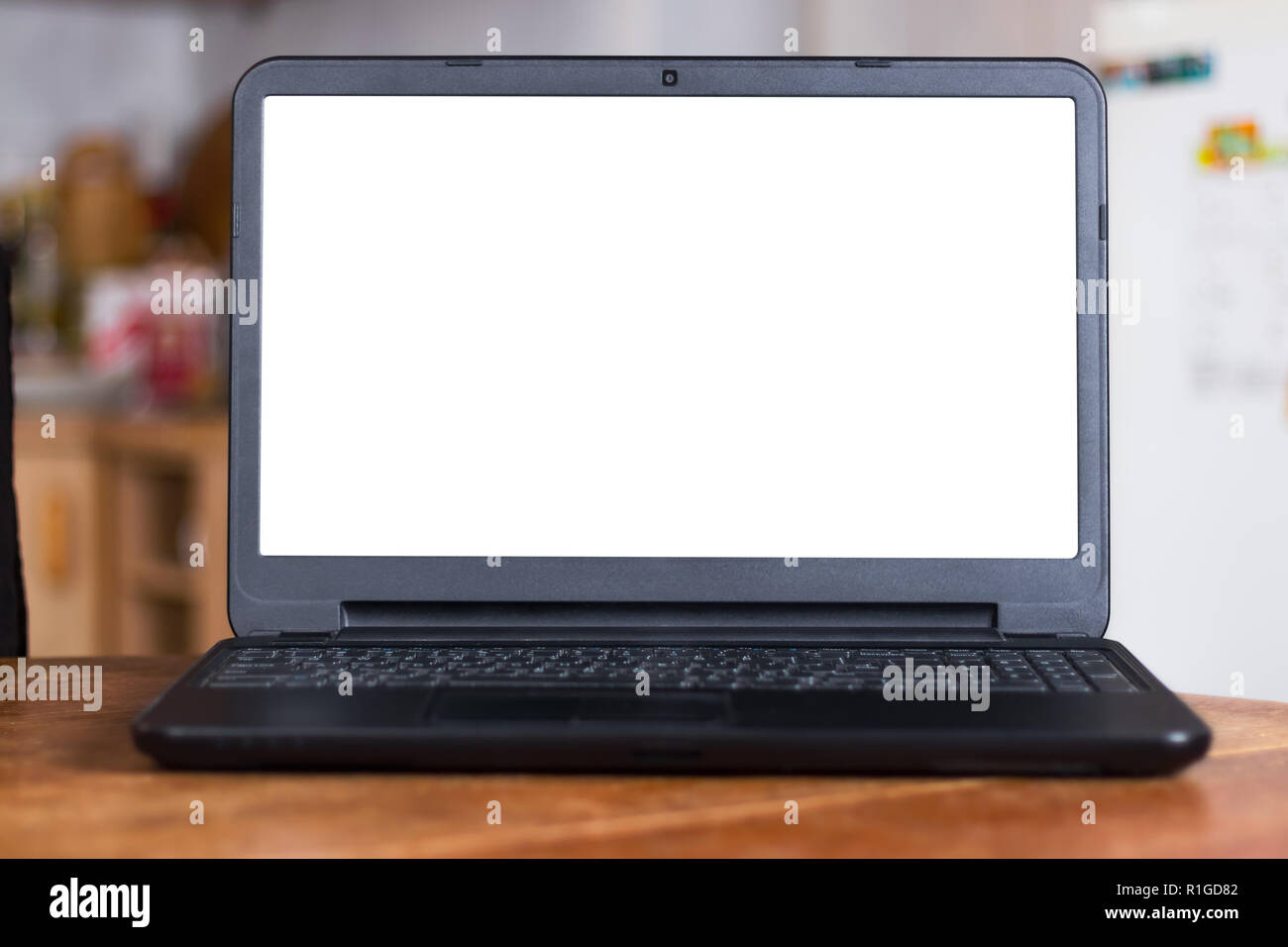 Laptop computer in vintage kitchen. Blank white screen ready for mockup ...