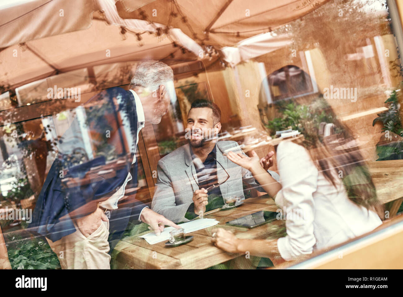 Business lunch. Three people in the restaurant sitting at table ...
