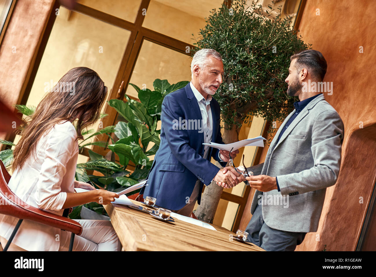 Business lunch. Three people in the restaurant sitting at table making ...