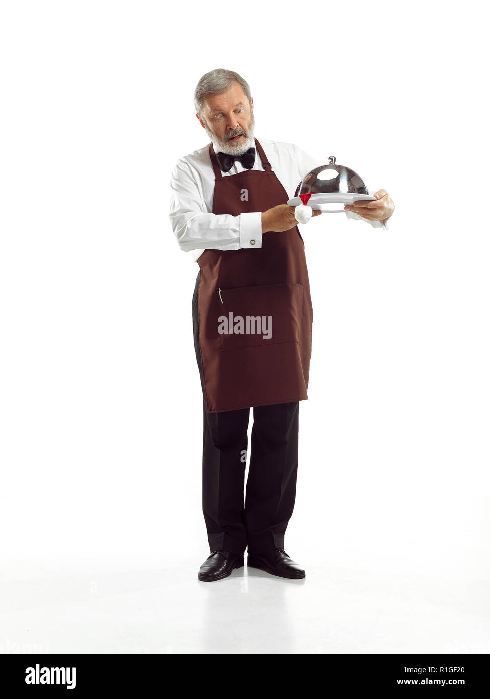 Senior waiter holding tray with Santa hat and standing isolated on ...