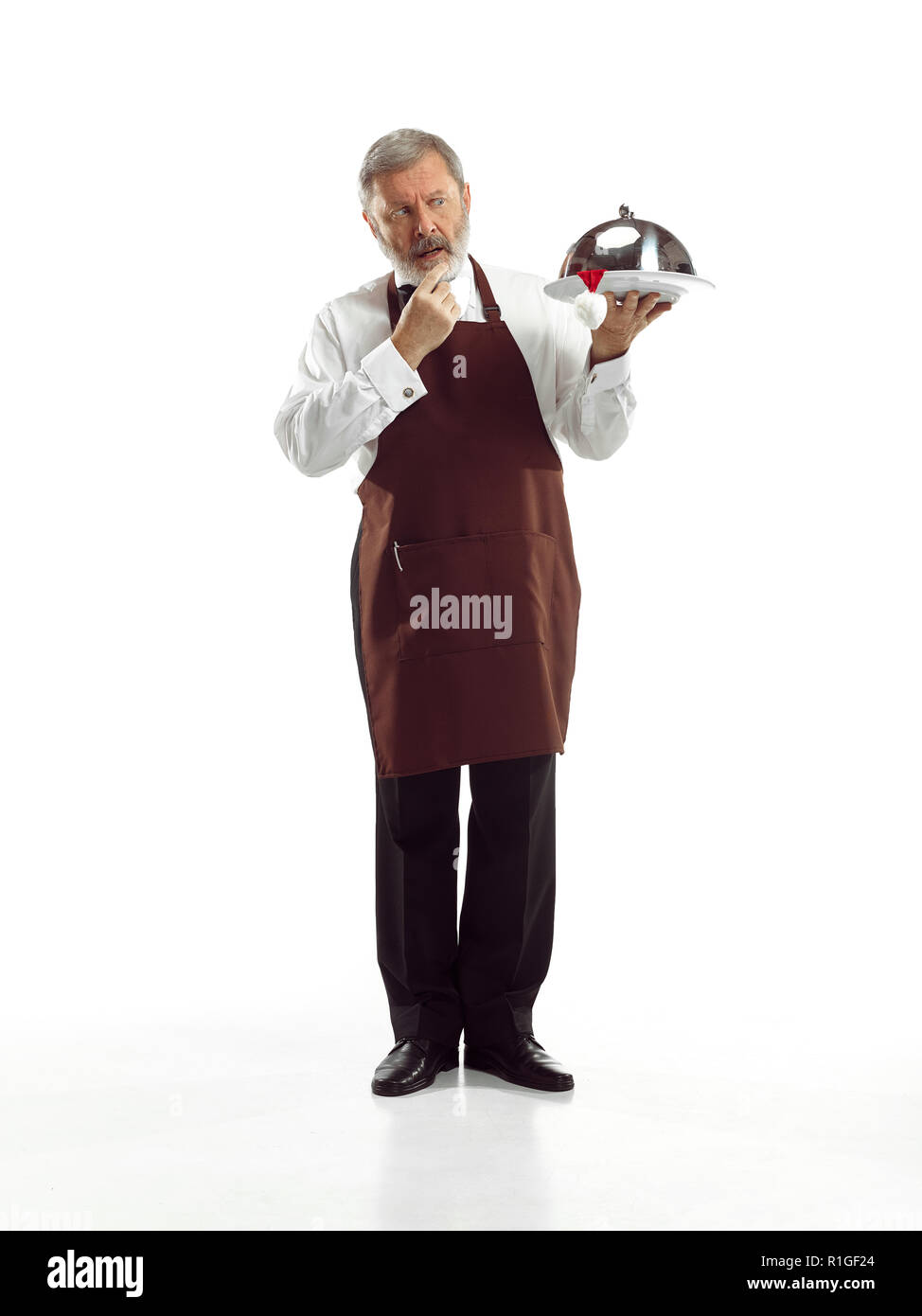 Senior waiter holding tray with Santa hat and standing isolated on ...