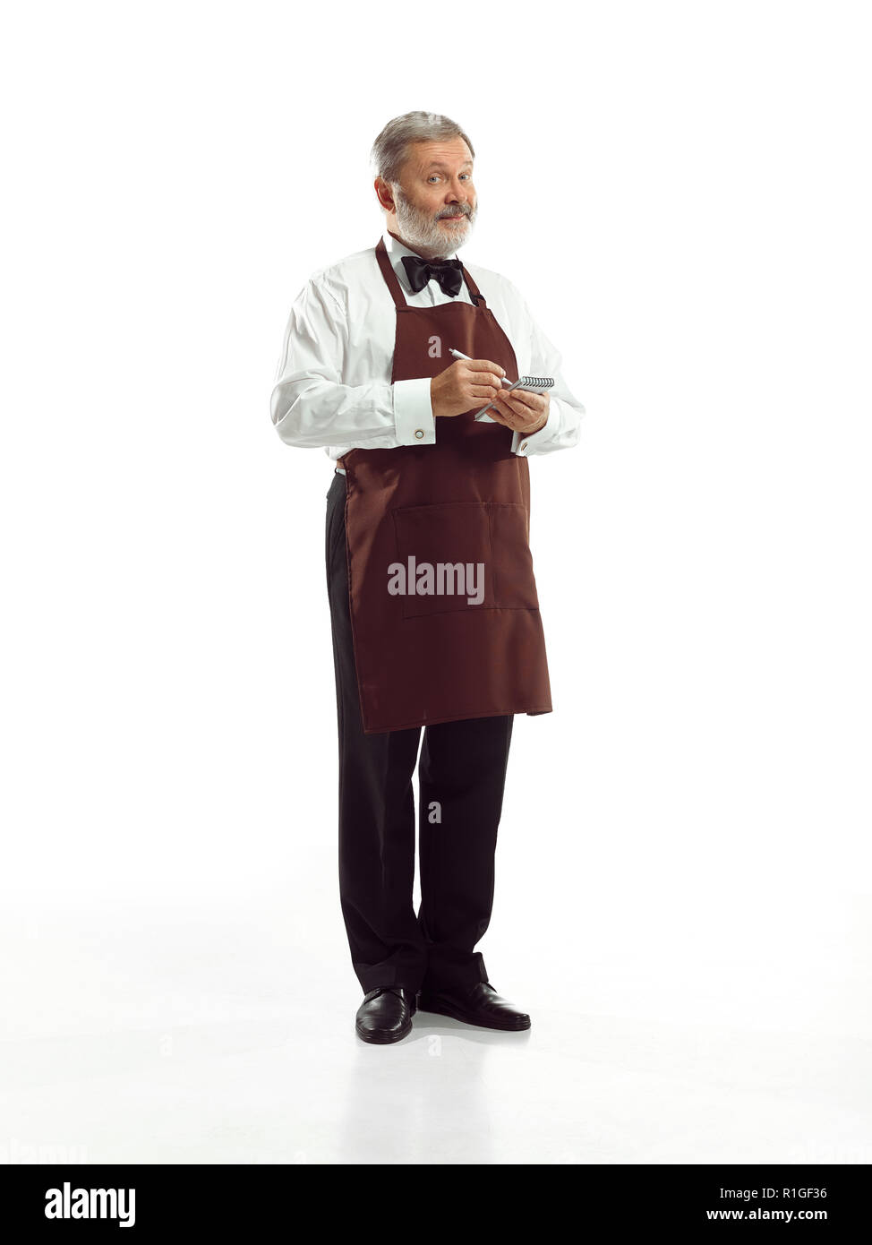 Senior waiter and standing isolated on white studio background. concept ...