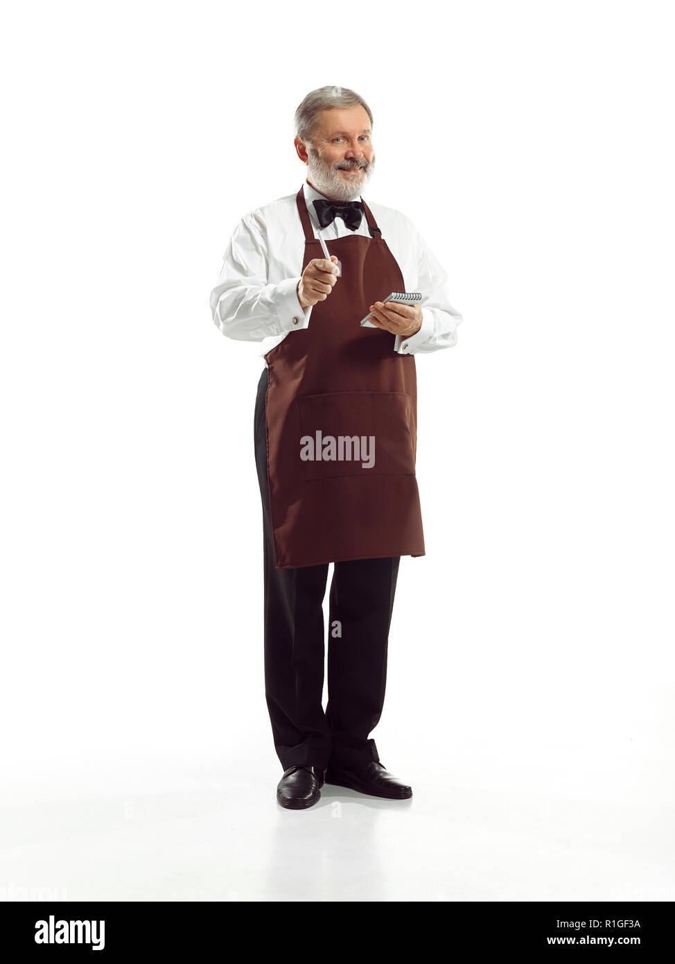 Senior waiter and standing isolated on white studio background. concept ...