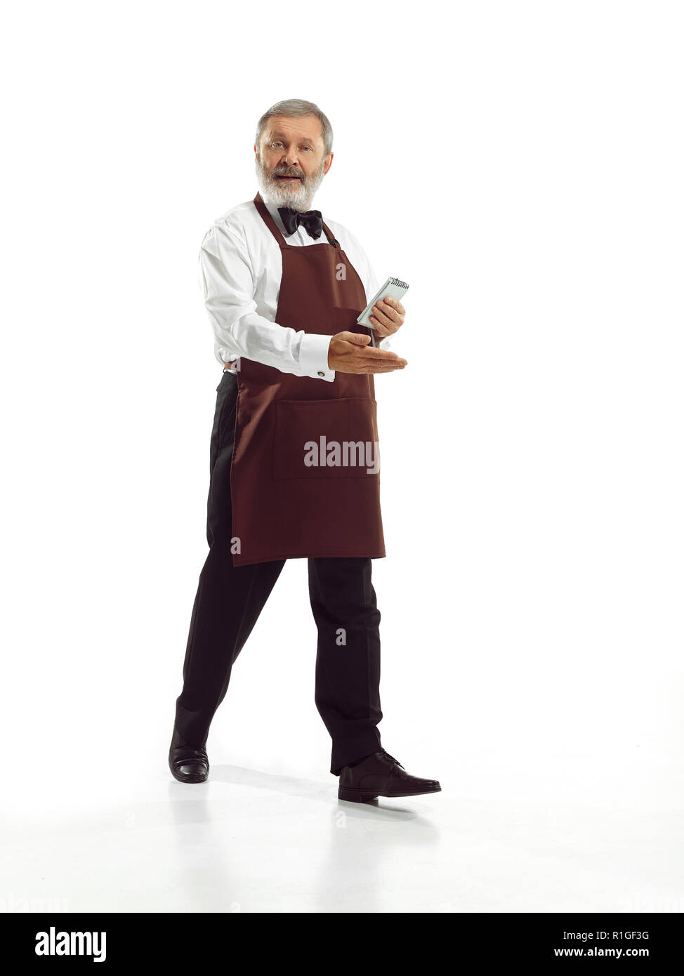 Senior waiter and standing isolated on white studio background. concept ...