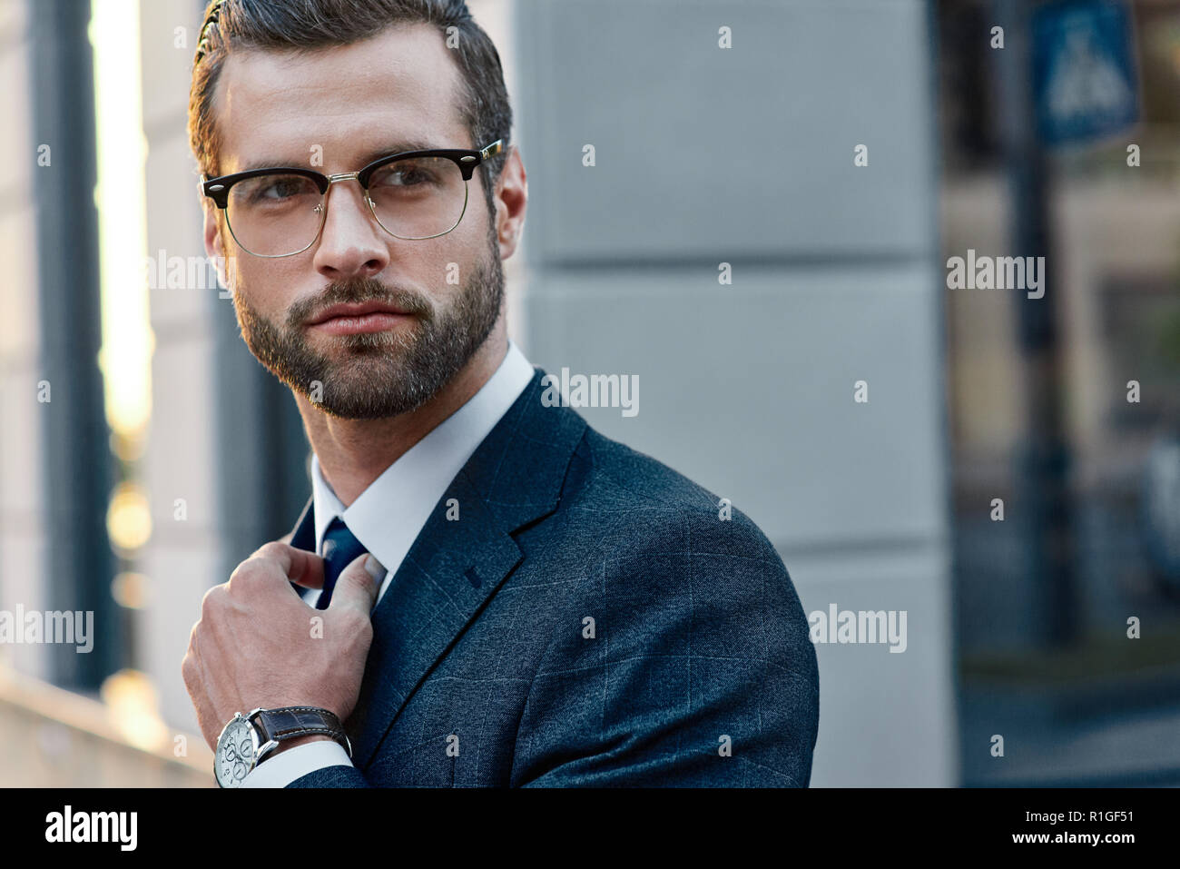 The young in spectacles men straightens his tie, his face unshaven ...