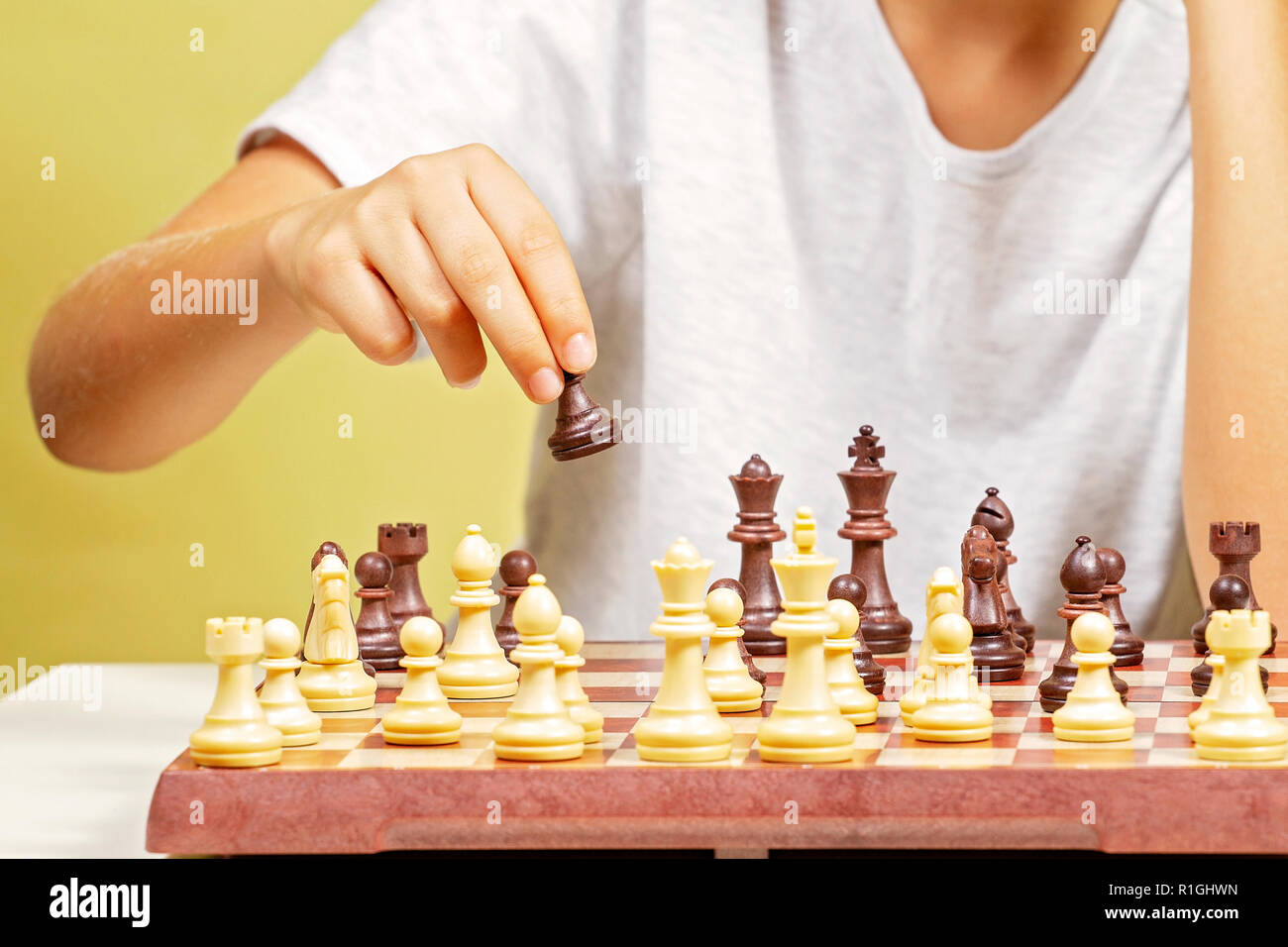 Kid sitting near chessboard and play chess game Stock Photo - Alamy