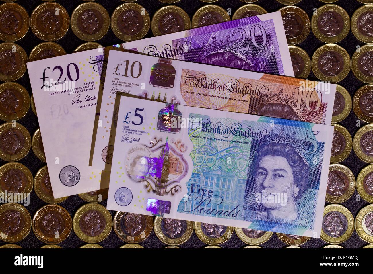 British banknotes with the new 12-side pound coins in the background ...