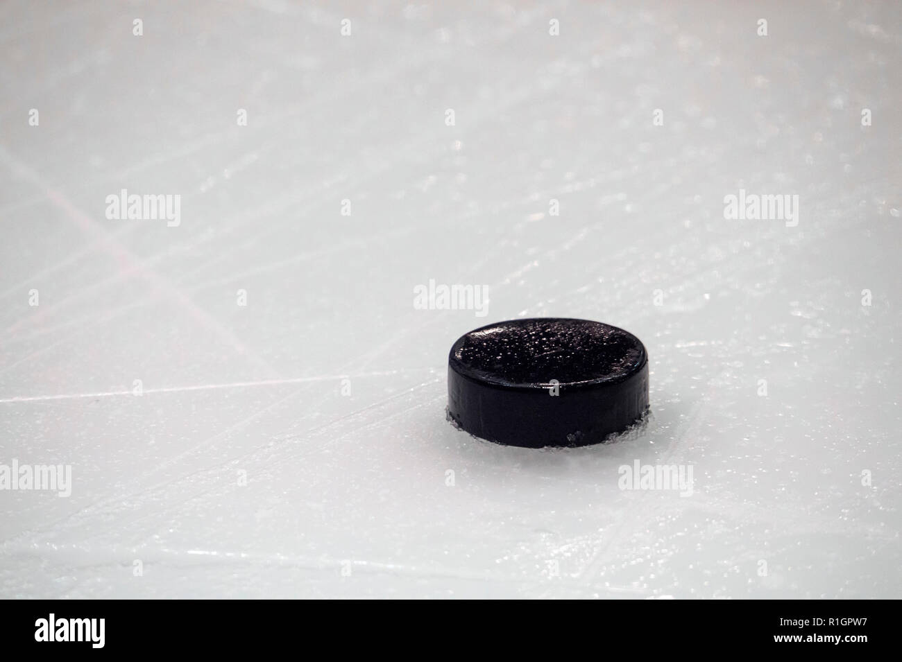 black hockey puck on ice rink. Winter sport Stock Photo - Alamy