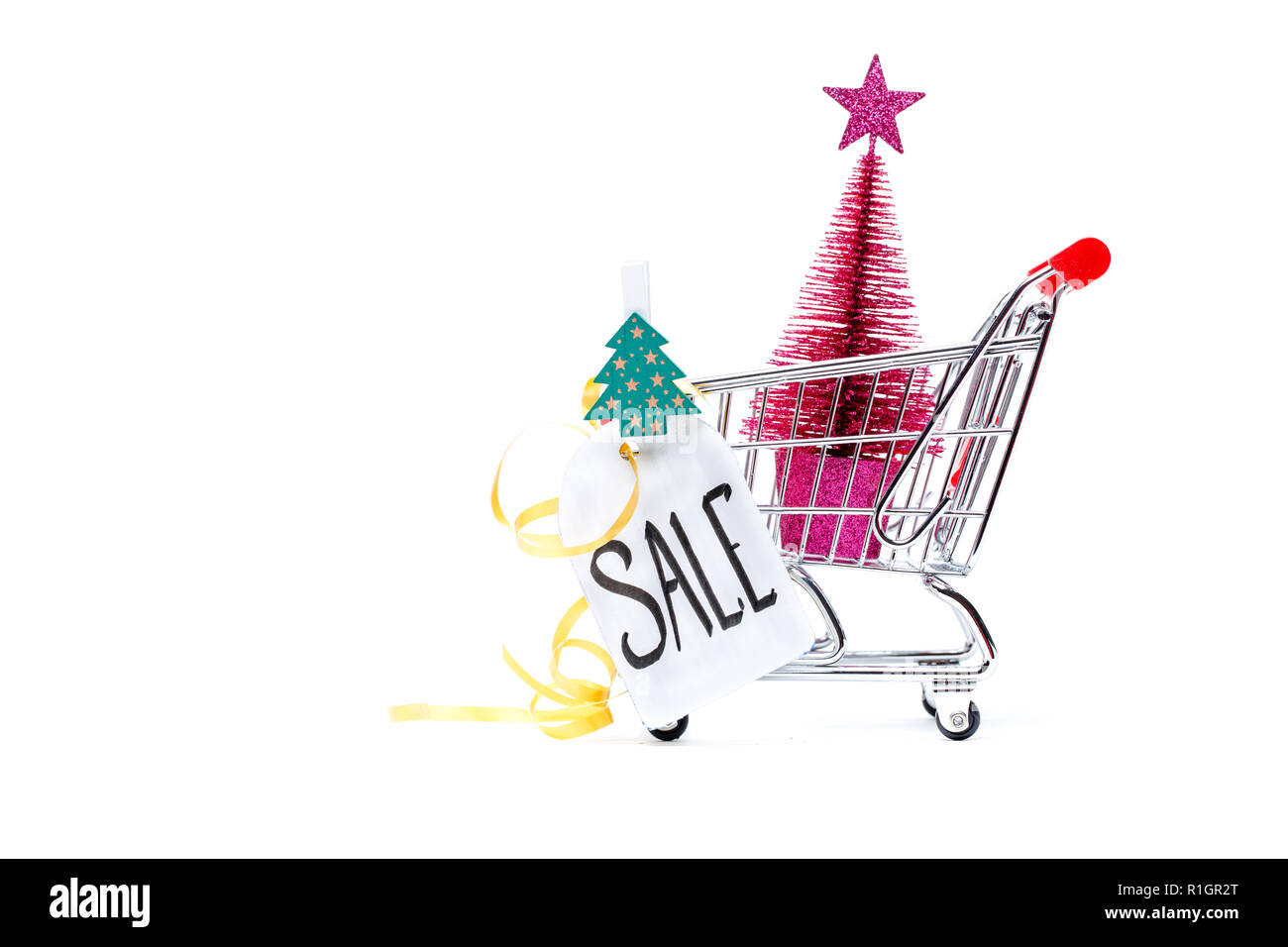 Image of cart with Christmas tree, greeting card, ribbon on empty white ...